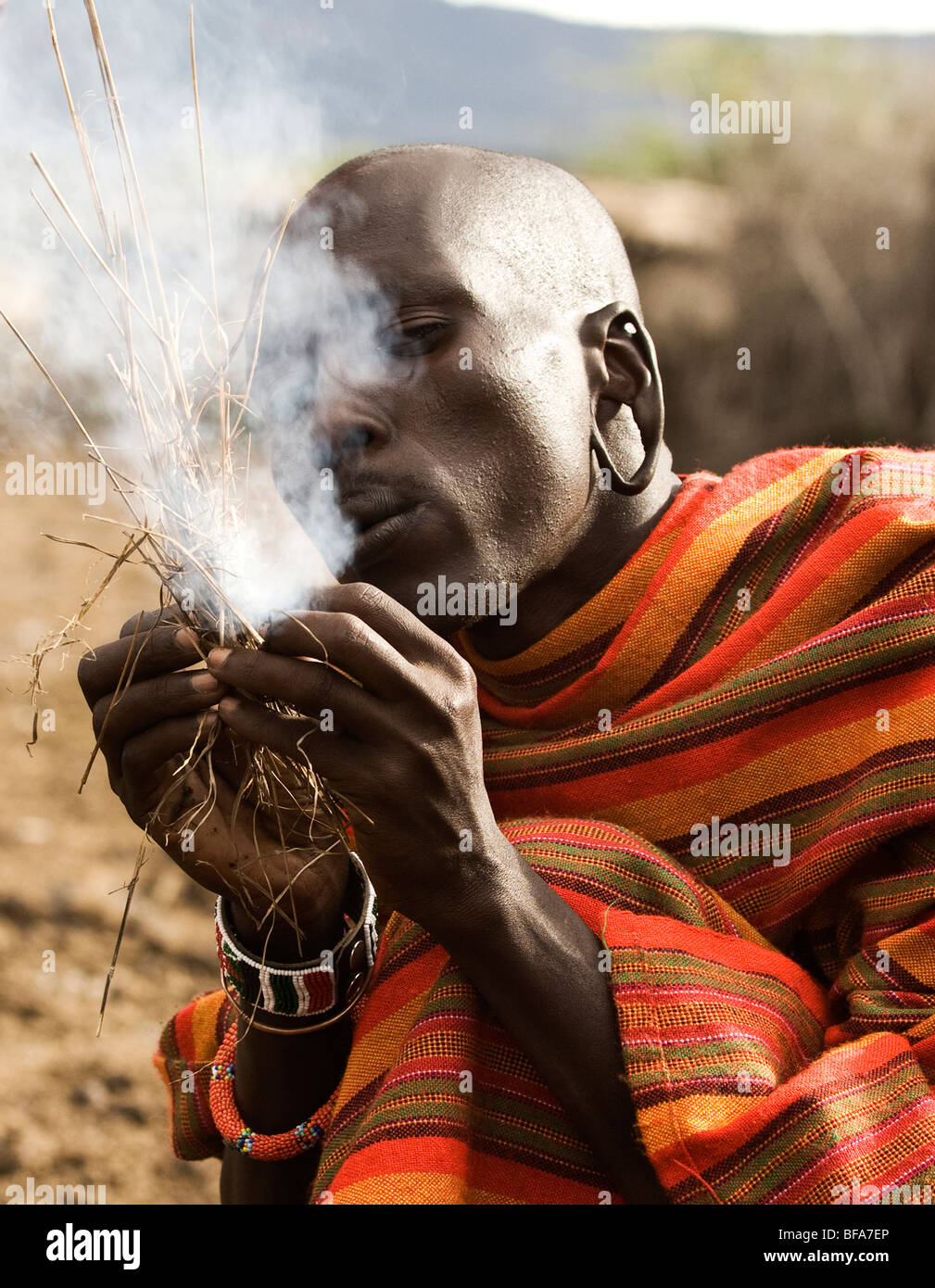 Masai man makes fire Stock Photo - Alamy