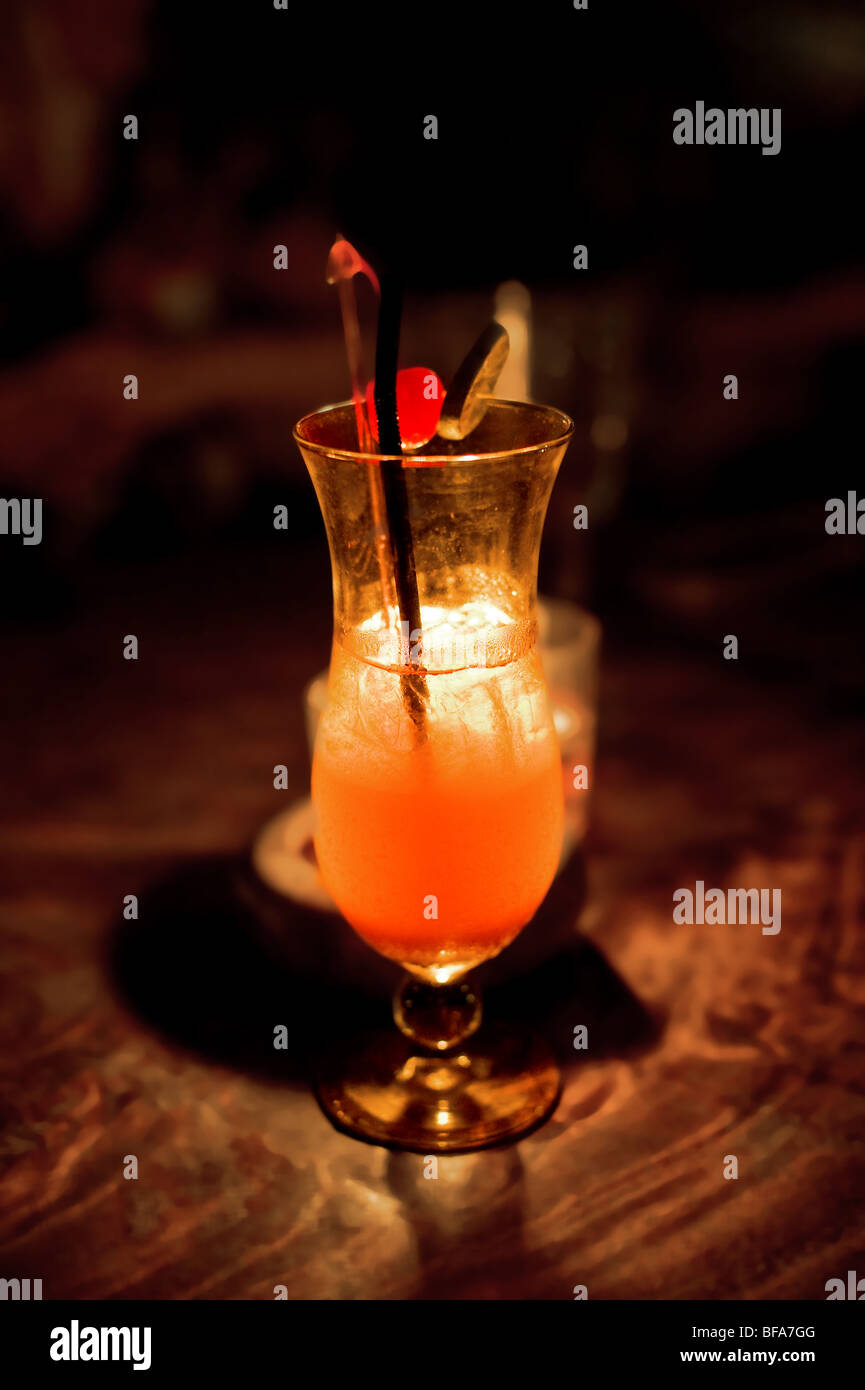 A cocktail glass back lit by the soft glow of candlelight. Photo by ...