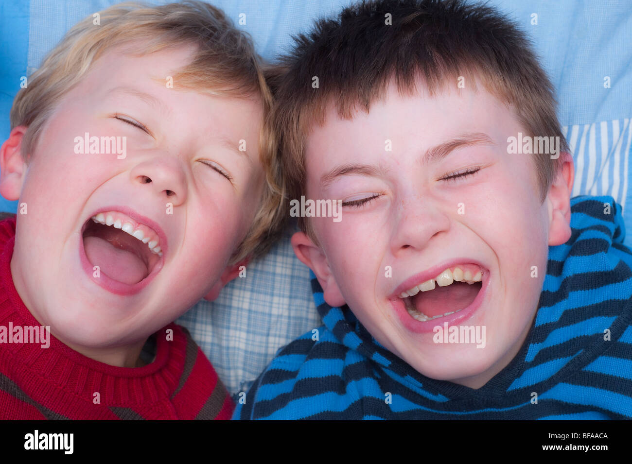A Model Released picture of two brothers ( 10 and 6 ) laughing indoors ...