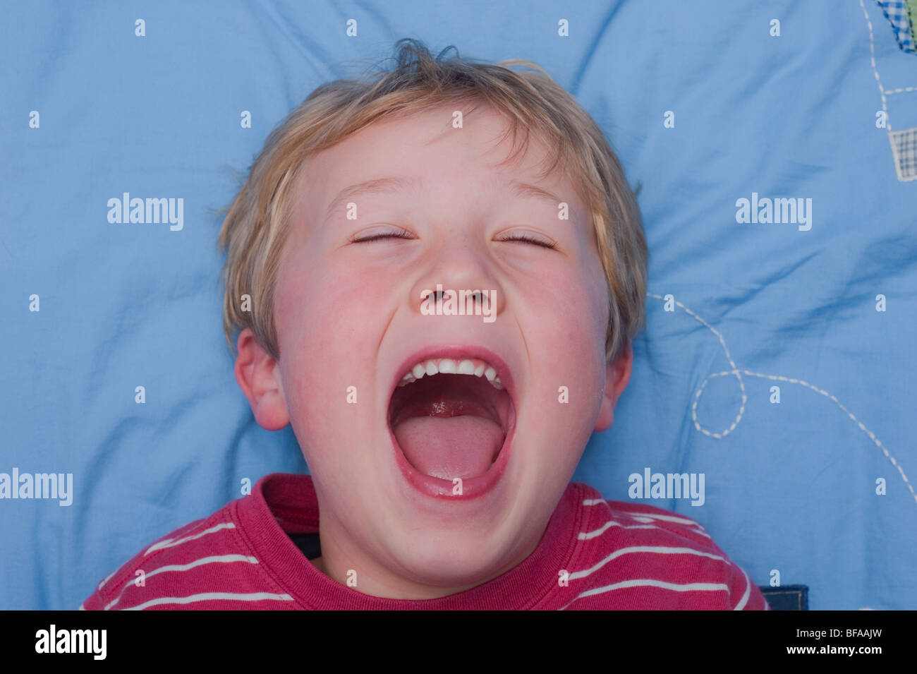 A Model Released picture of a six year old boy laughing indoors in the ...