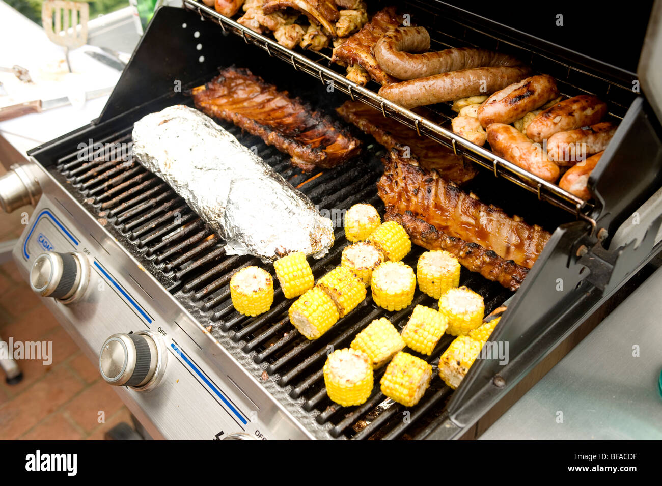 Barbecued ribs and grilled corn sausage at a South African Braai ...
