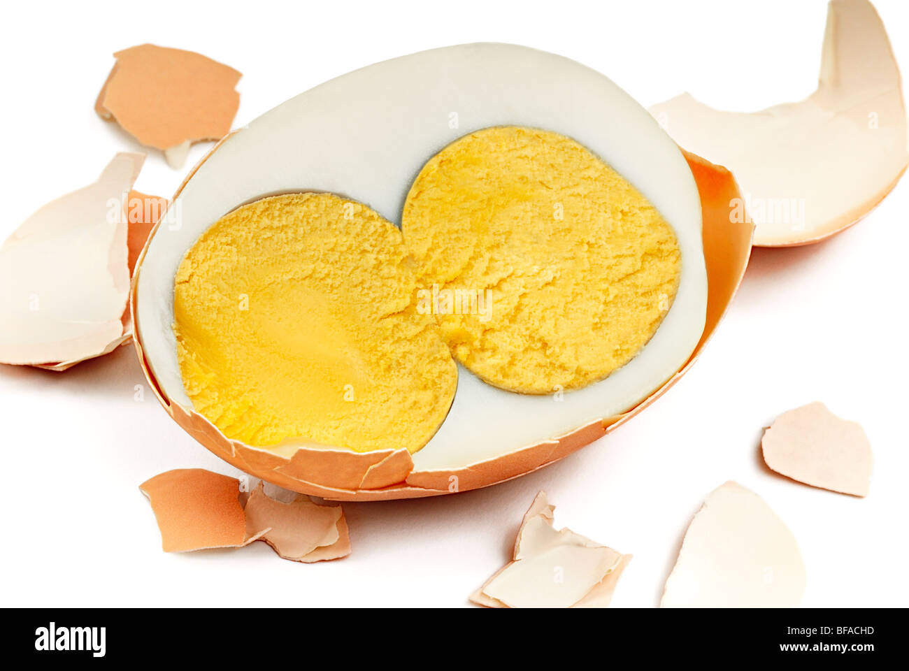 Halved hard-boiled egg with two egg yolks on a white background. Macro ...