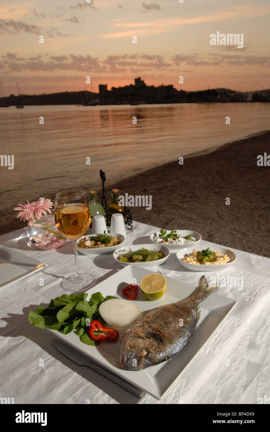 seafood and snacks on the dinner table at the Bodrum beach in sunset ...
