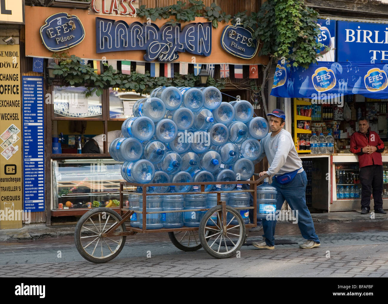 Man pushing a car of bottles with water in Istanbul Stock Photo - Alamy