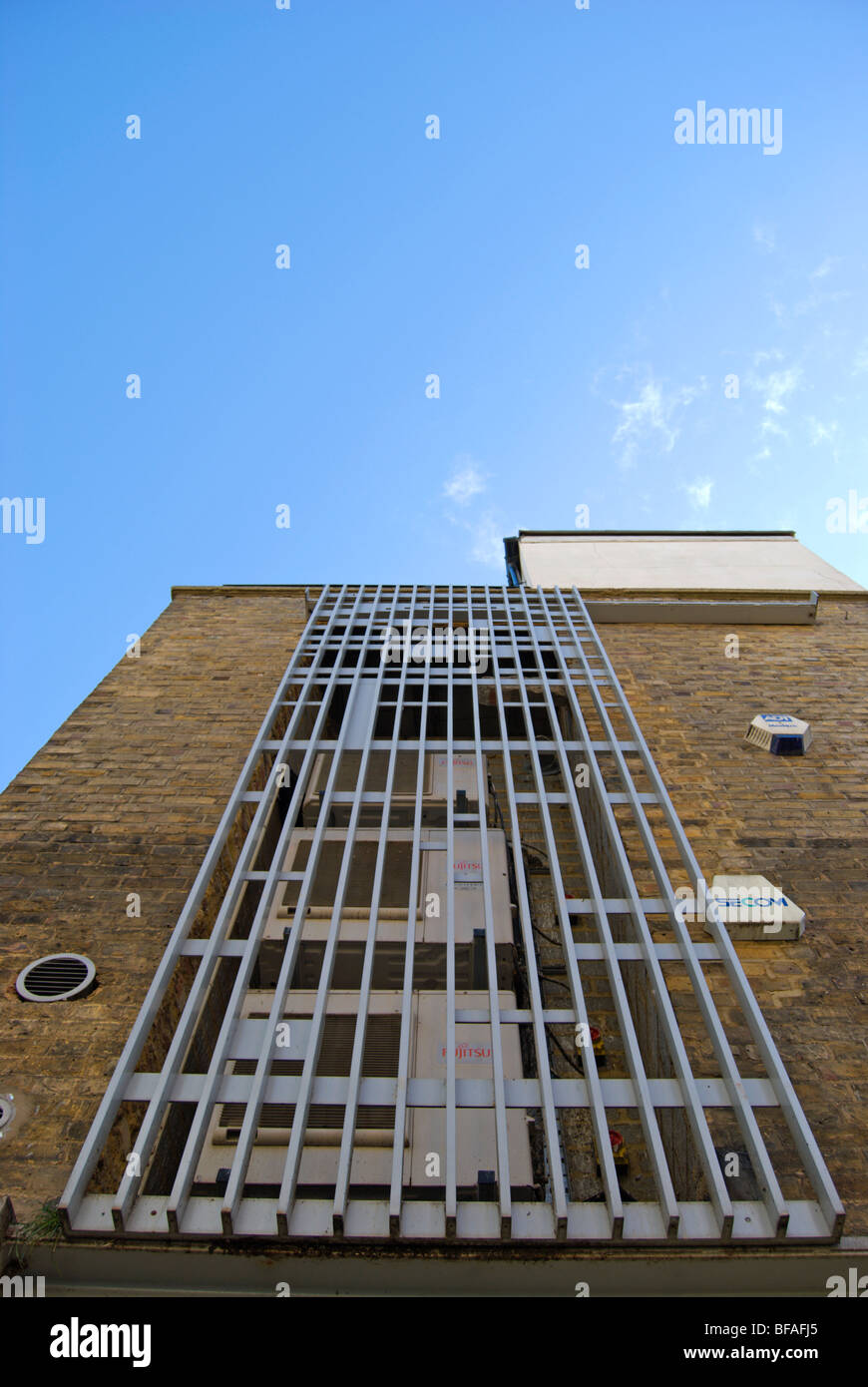 iron grille on an exterior wall protecting a row of air conditioning ...
