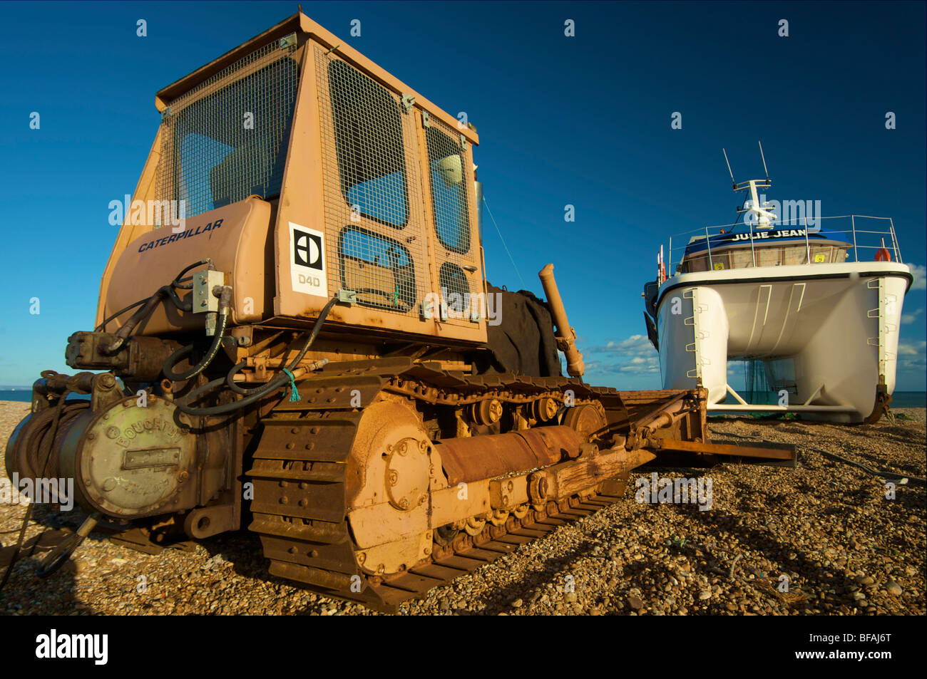 tractor in beach in front of fishing boat Stock Photo - Alamy