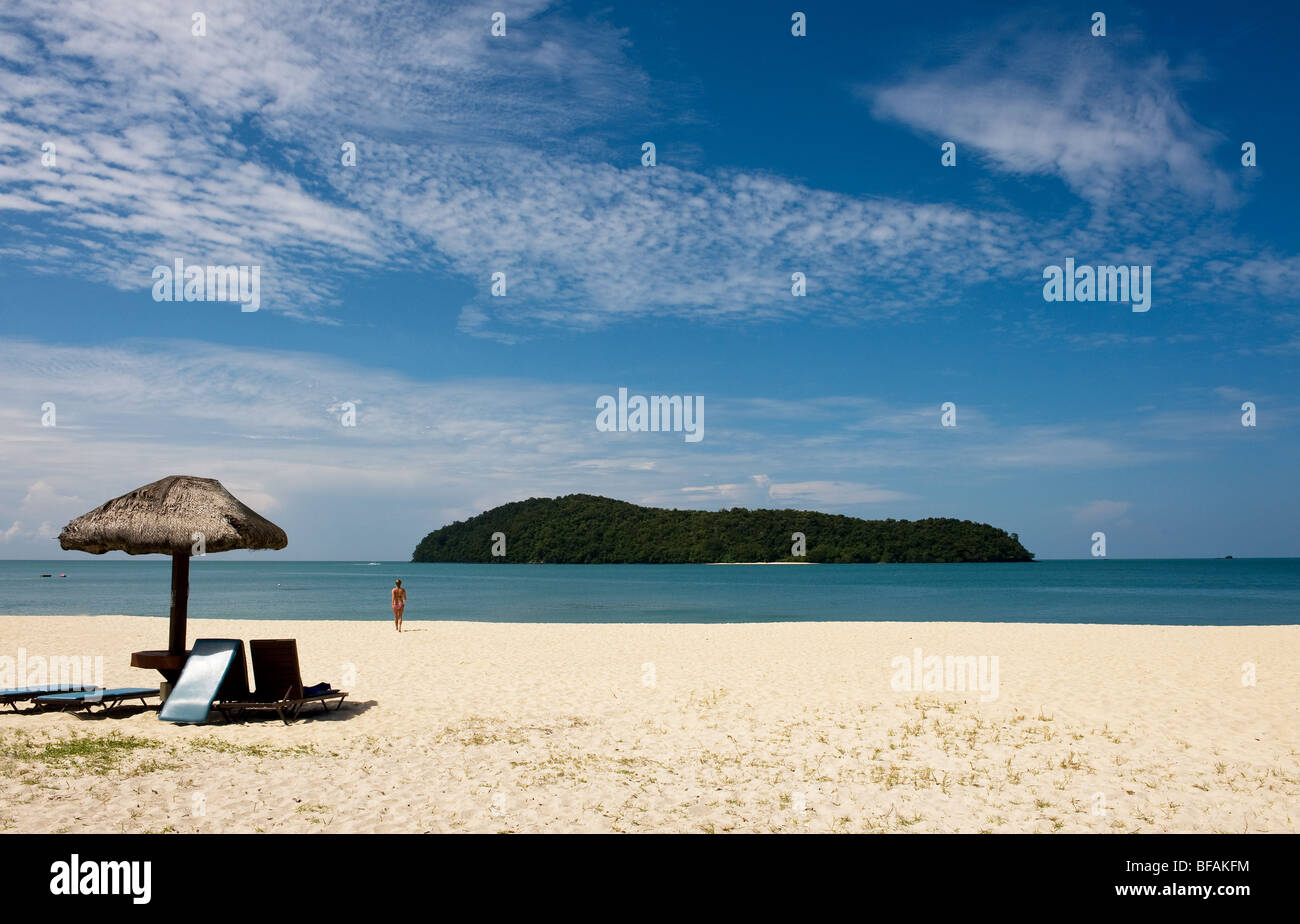 A female holidaymaker walking towards the sea on Pantai Tengah beach in ...