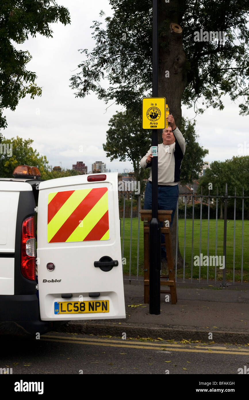 A Lambeth council employee hangs a new Neighbourhood Watch sign on a ...