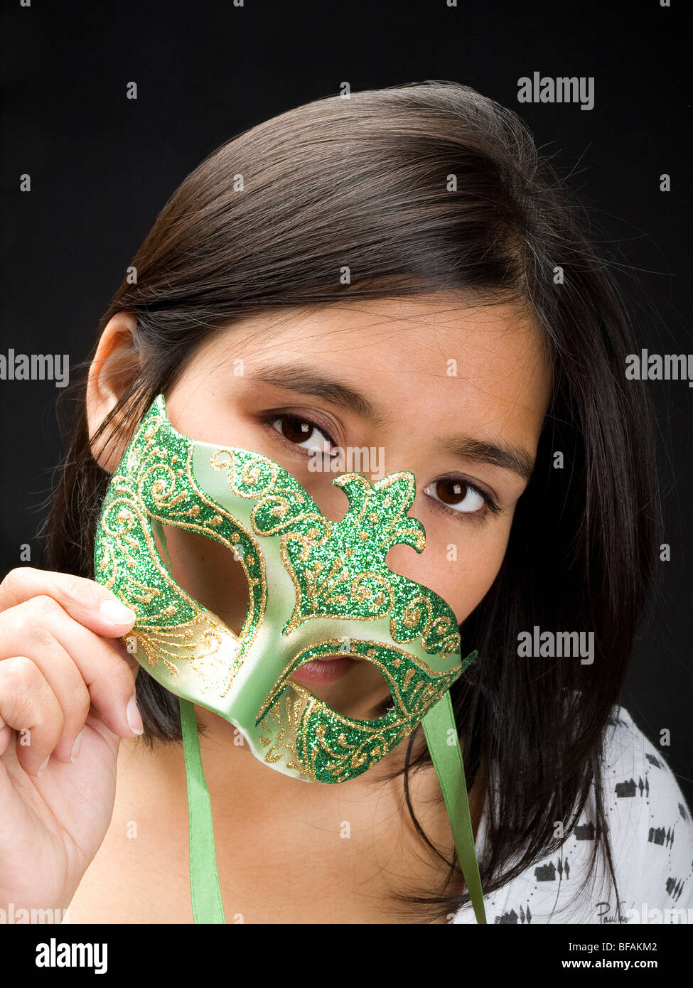 A young girl holding a decorative mask Stock Photo - Alamy
