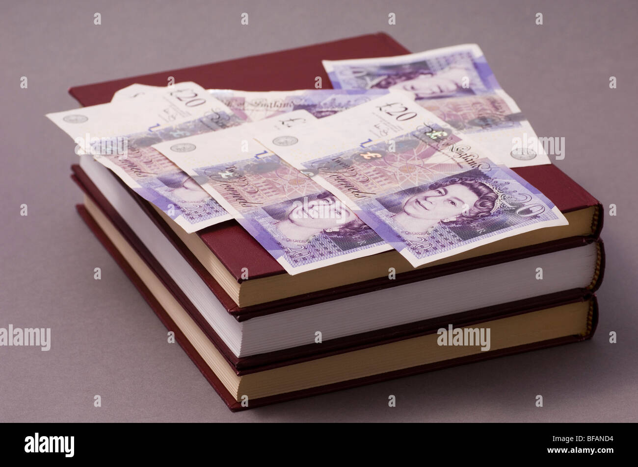 British money over a stack of books Stock Photo - Alamy