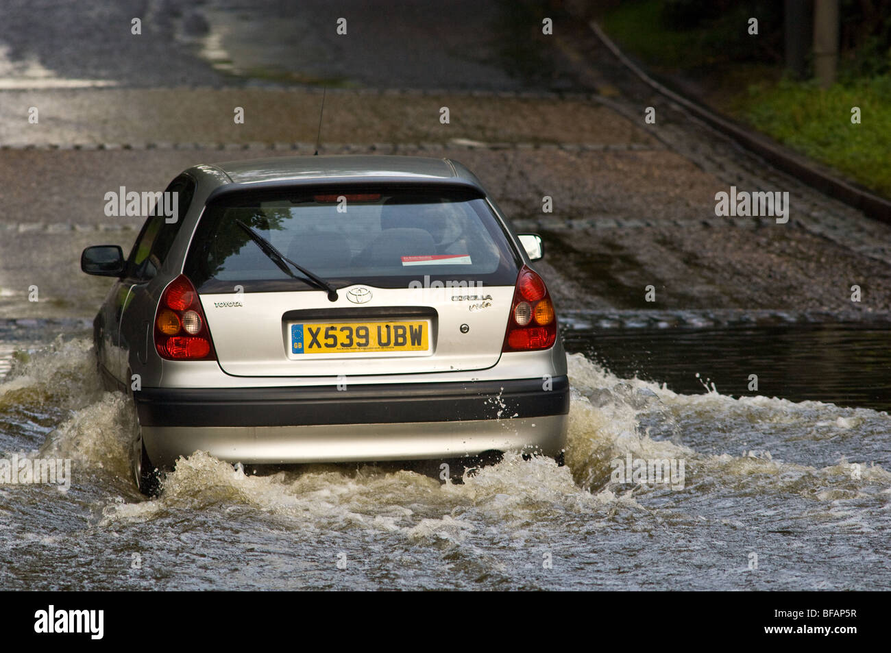 Motor vehicles driving through a flooded weir Stock Photo - Alamy