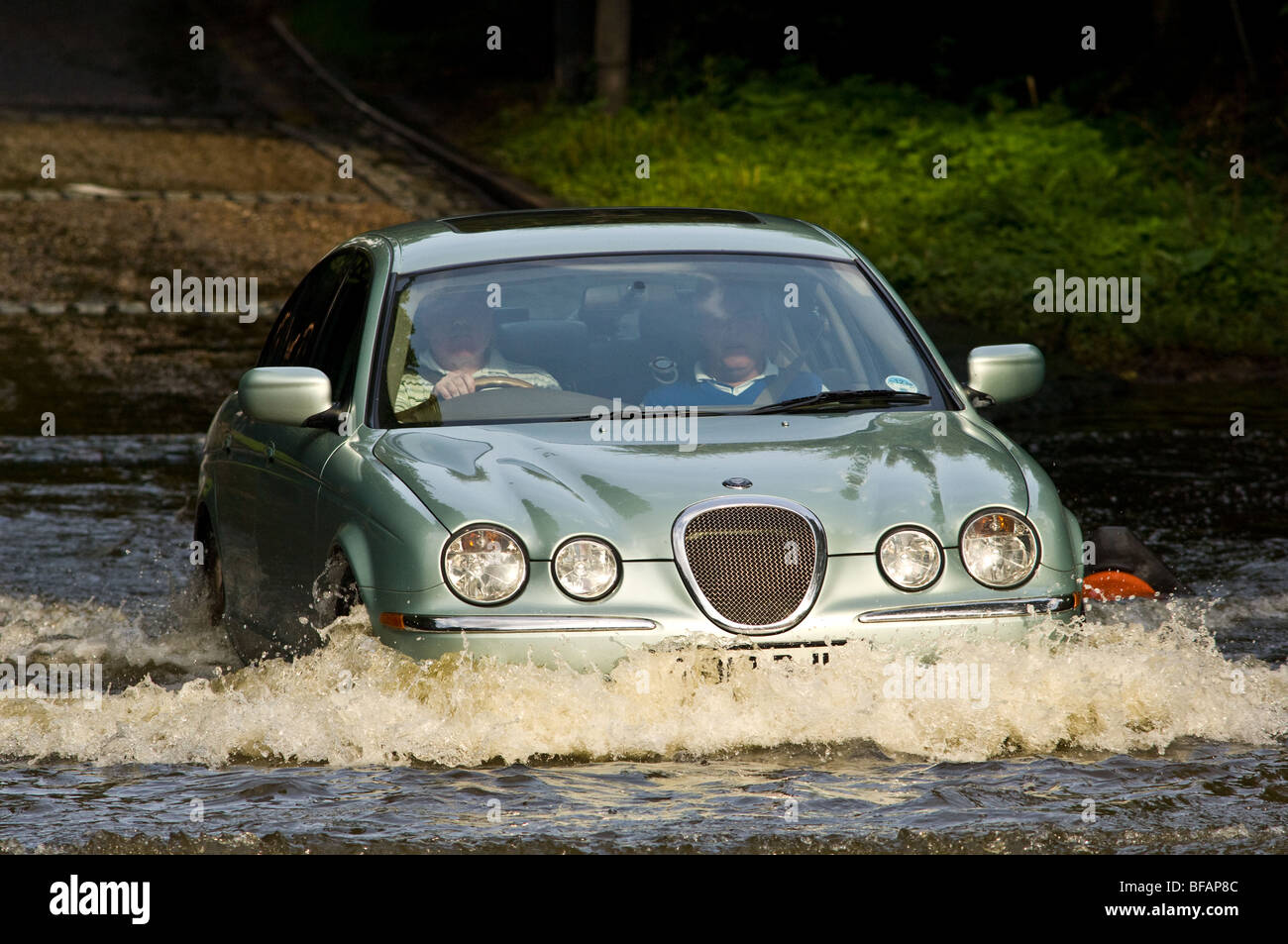 Motor vehicles driving through a flooded weir Stock Photo - Alamy
