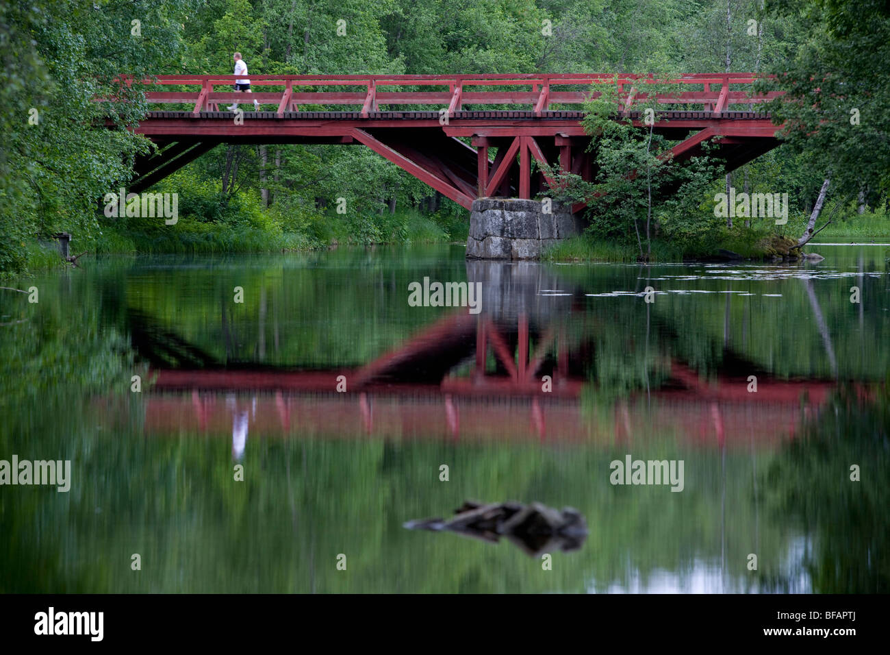 Runner on red wooden bridge Lejonstromsbron, Skelleftea, Vasterbottens ...