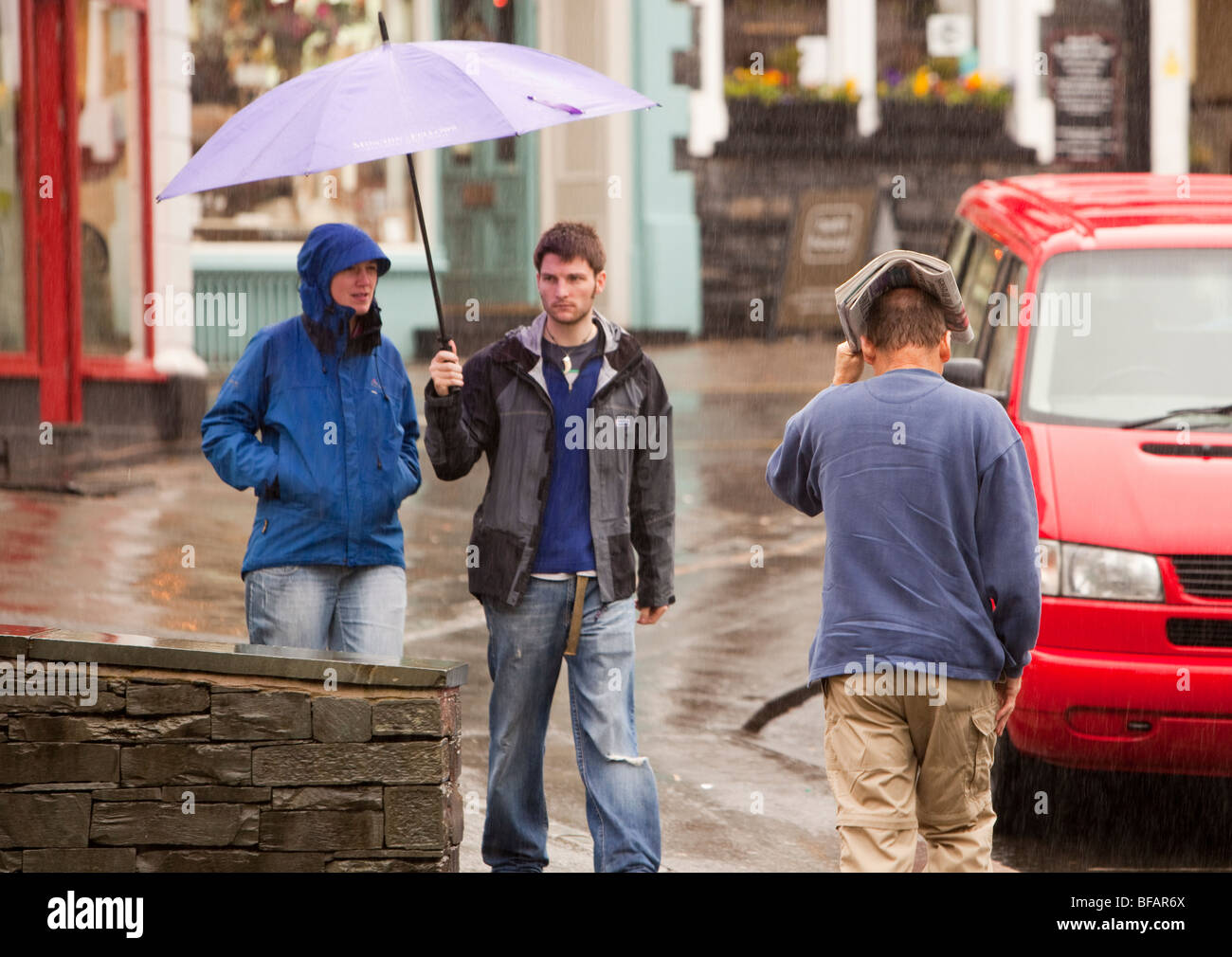People using umbrella's and a man sheltering under a newspaper in the ...