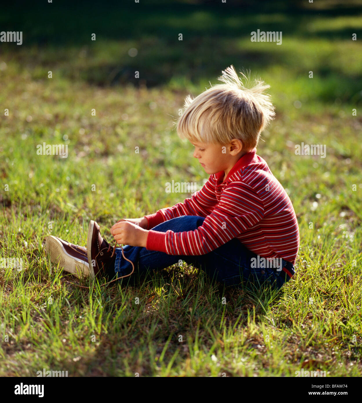 Young boy tying shoe Stock Photo - Alamy