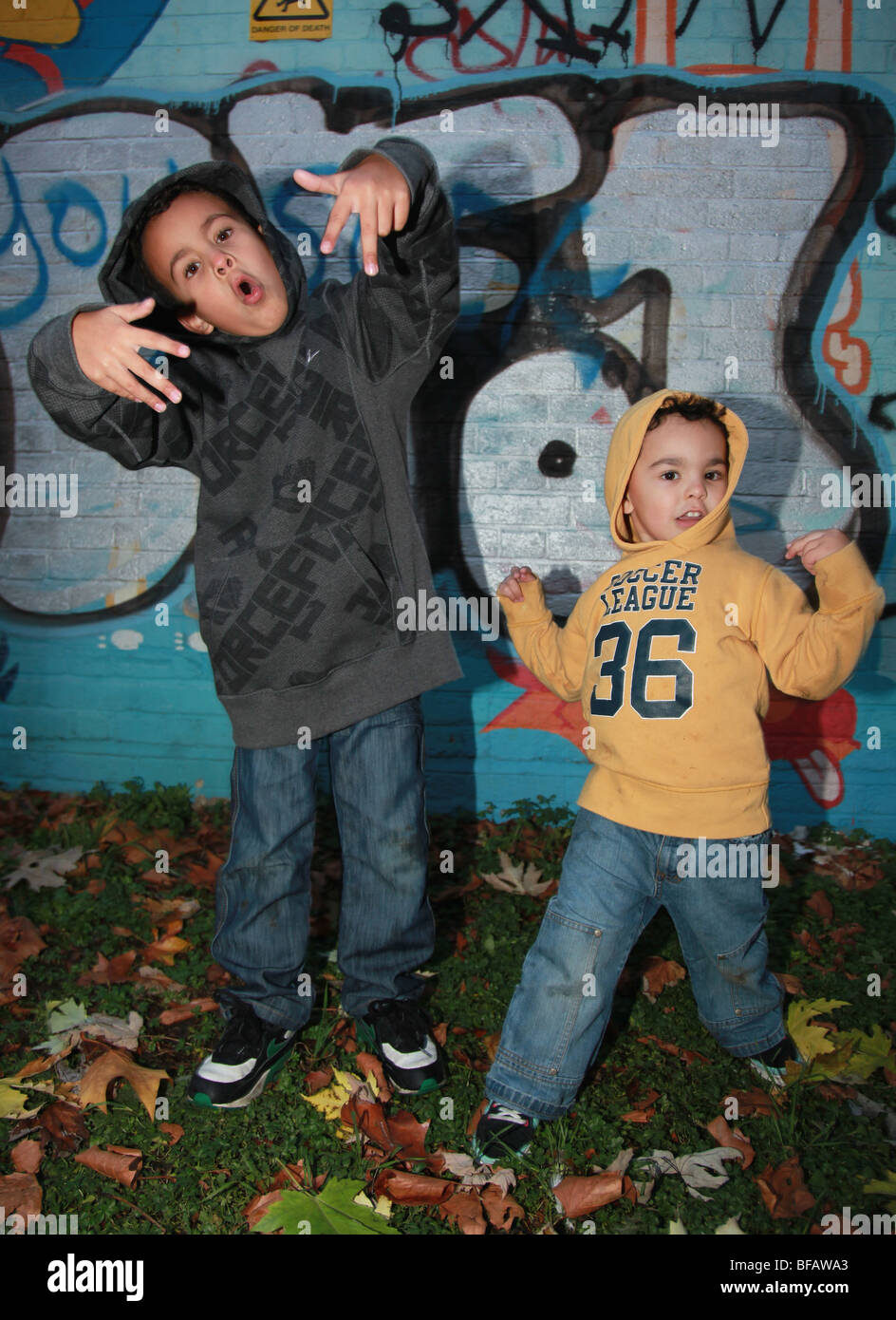 Young boys giving attitude by graffiti wall Stock Photo - Alamy