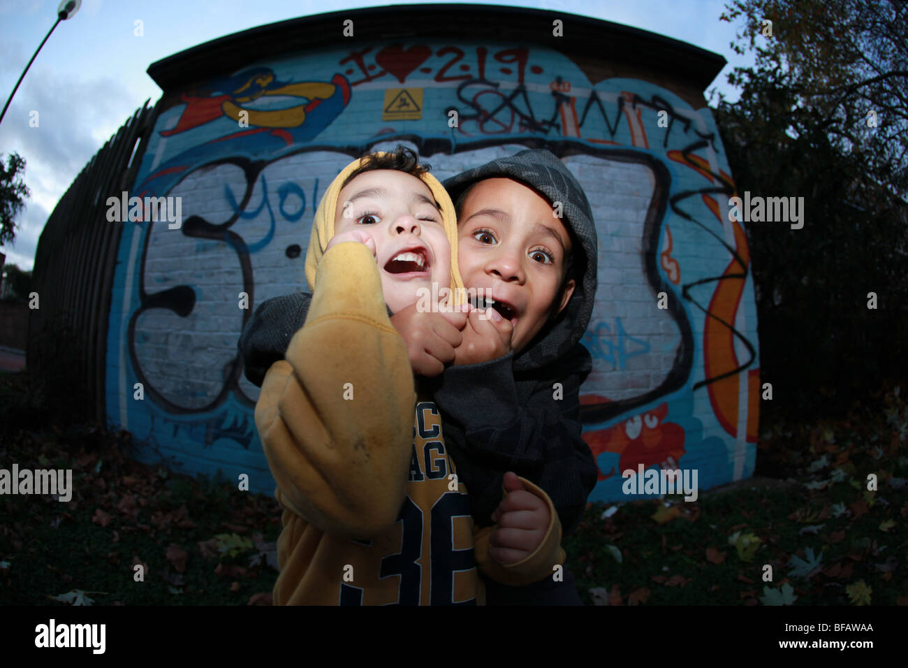 Young boys giving attitude by graffiti wall Stock Photo - Alamy