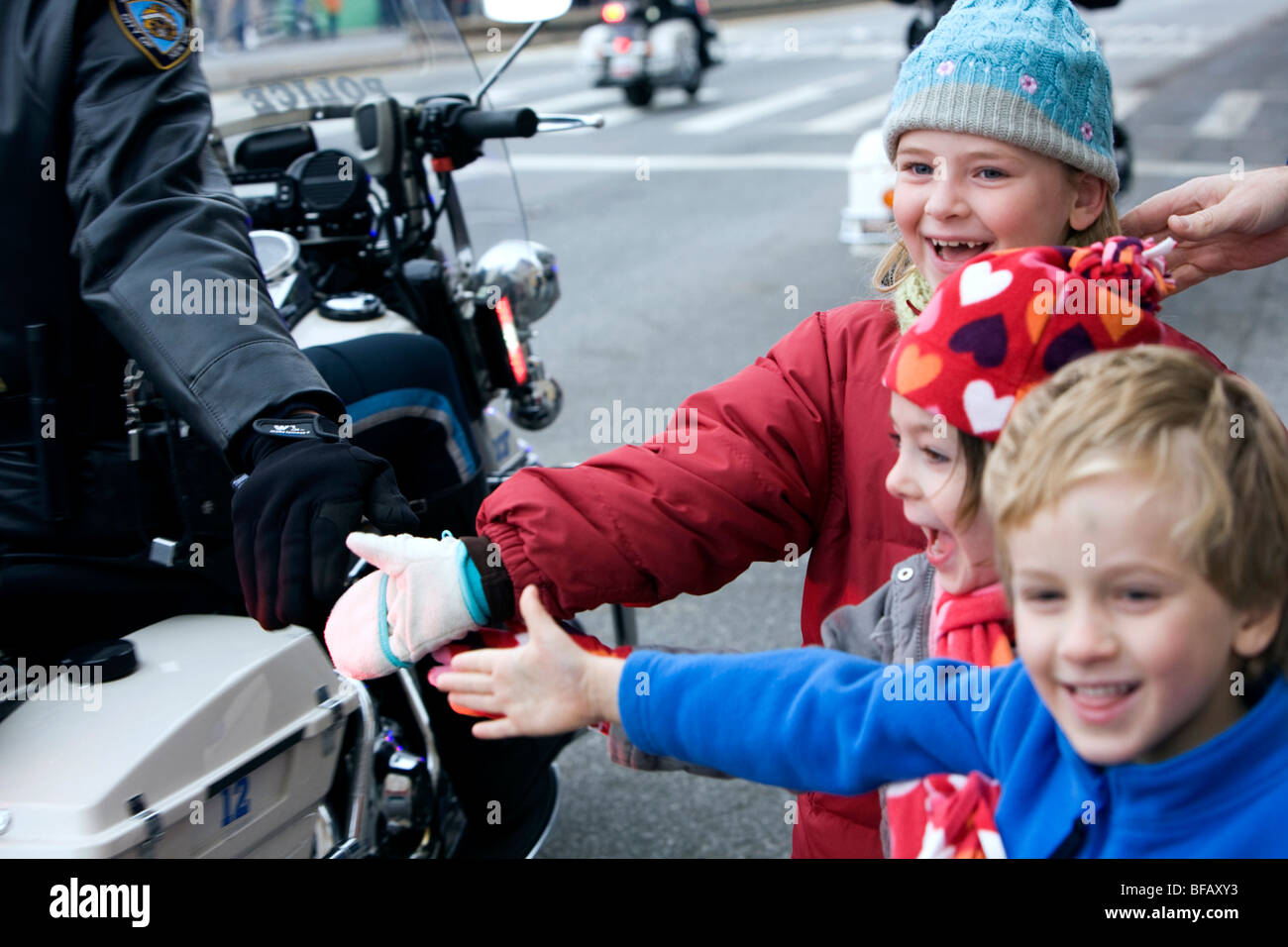 Children slap hands with a police officer patrolling the course near ...
