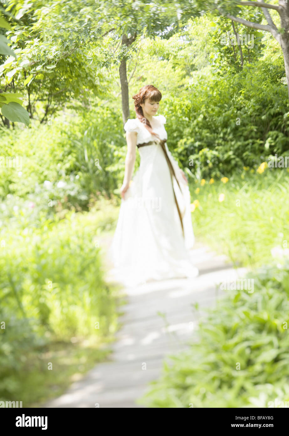 Bride walking through a forest Stock Photo - Alamy