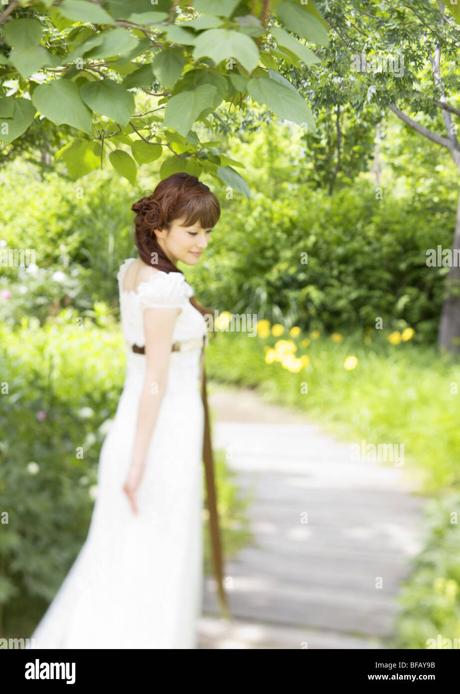 Bride walking through a forest Stock Photo - Alamy