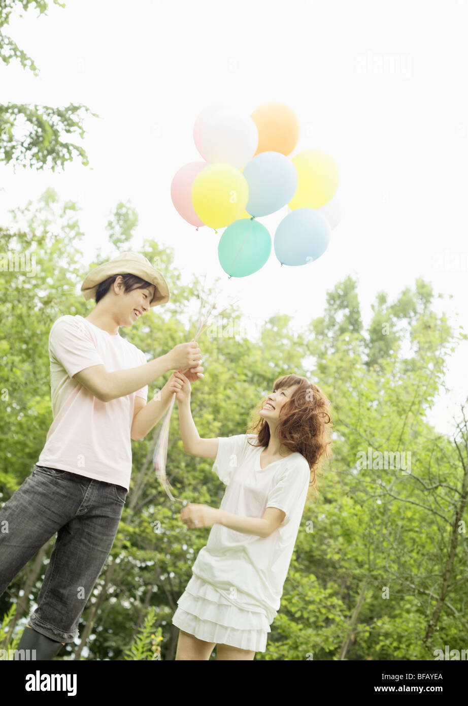 Young couple holding balloon Stock Photo - Alamy