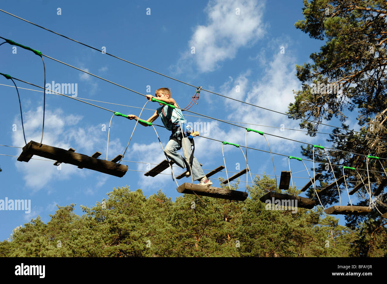 Ten Year Boy Crossing Wobbly Rope & Timber Bridge in an Outdoor Forest ...