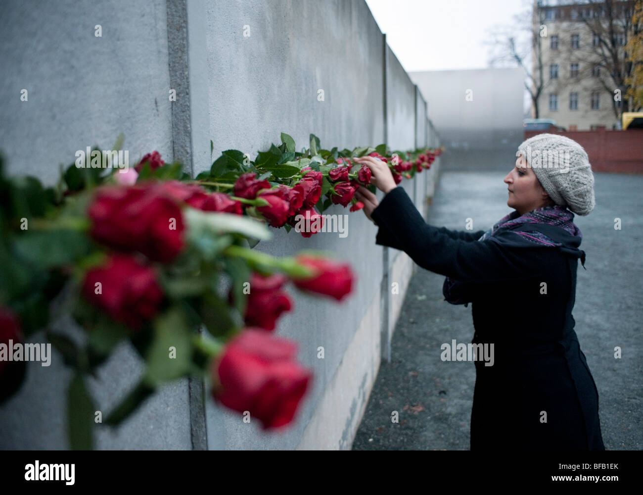 Woman placing red rose in Berlin Wall on 20th anniversary of the fall ...