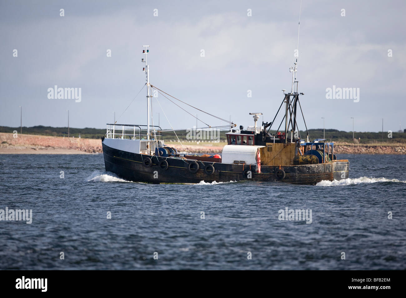 Fishing trawler heading for the open seas Stock Photo - Alamy