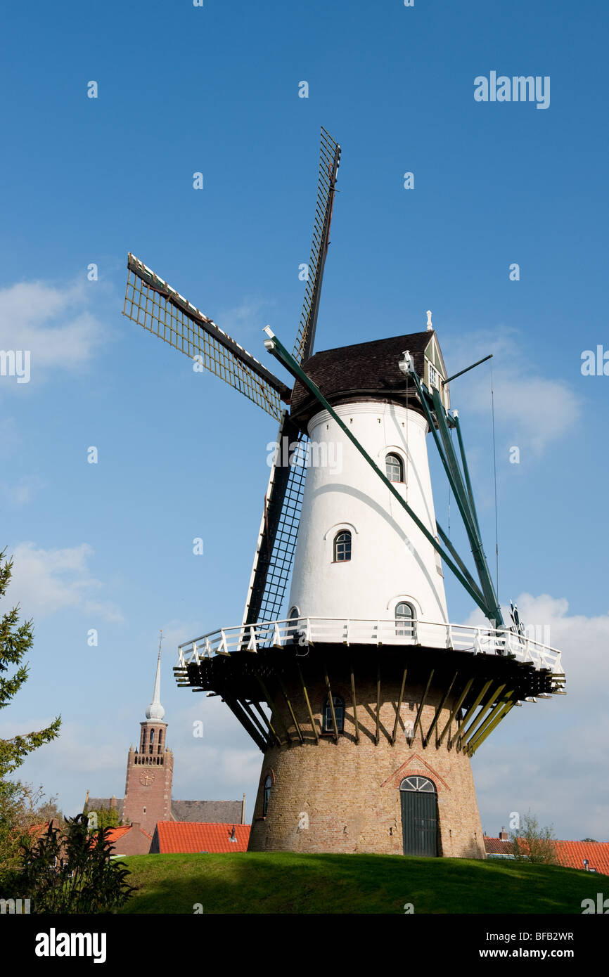 Typical Dutch windmill IJzendijke with church in the background Stock ...