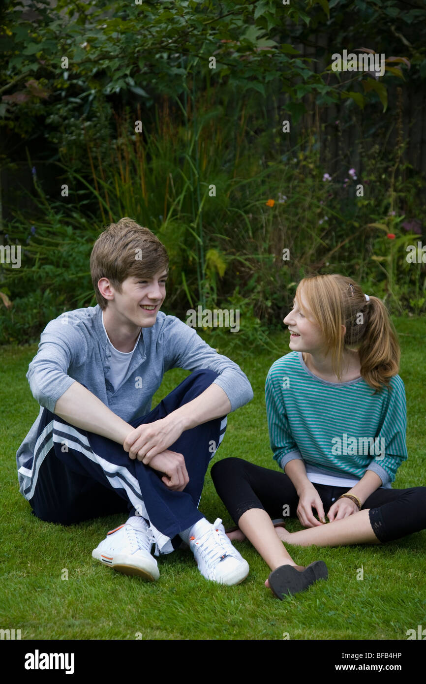 Two teenagers chat in the garden Stock Photo - Alamy