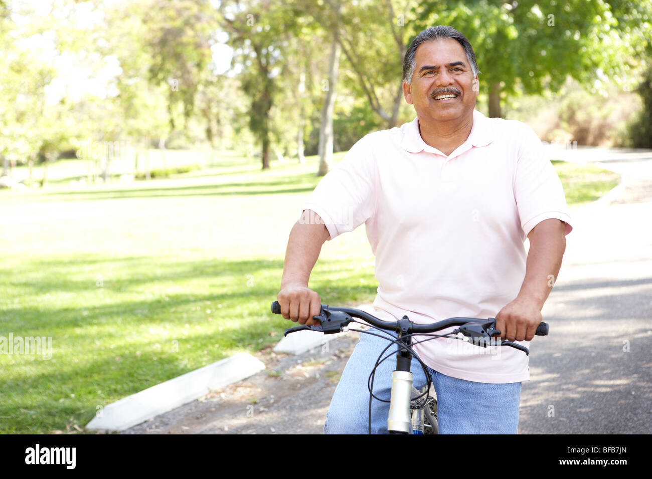 Senior Man Riding Bike In Park Stock Photo - Alamy