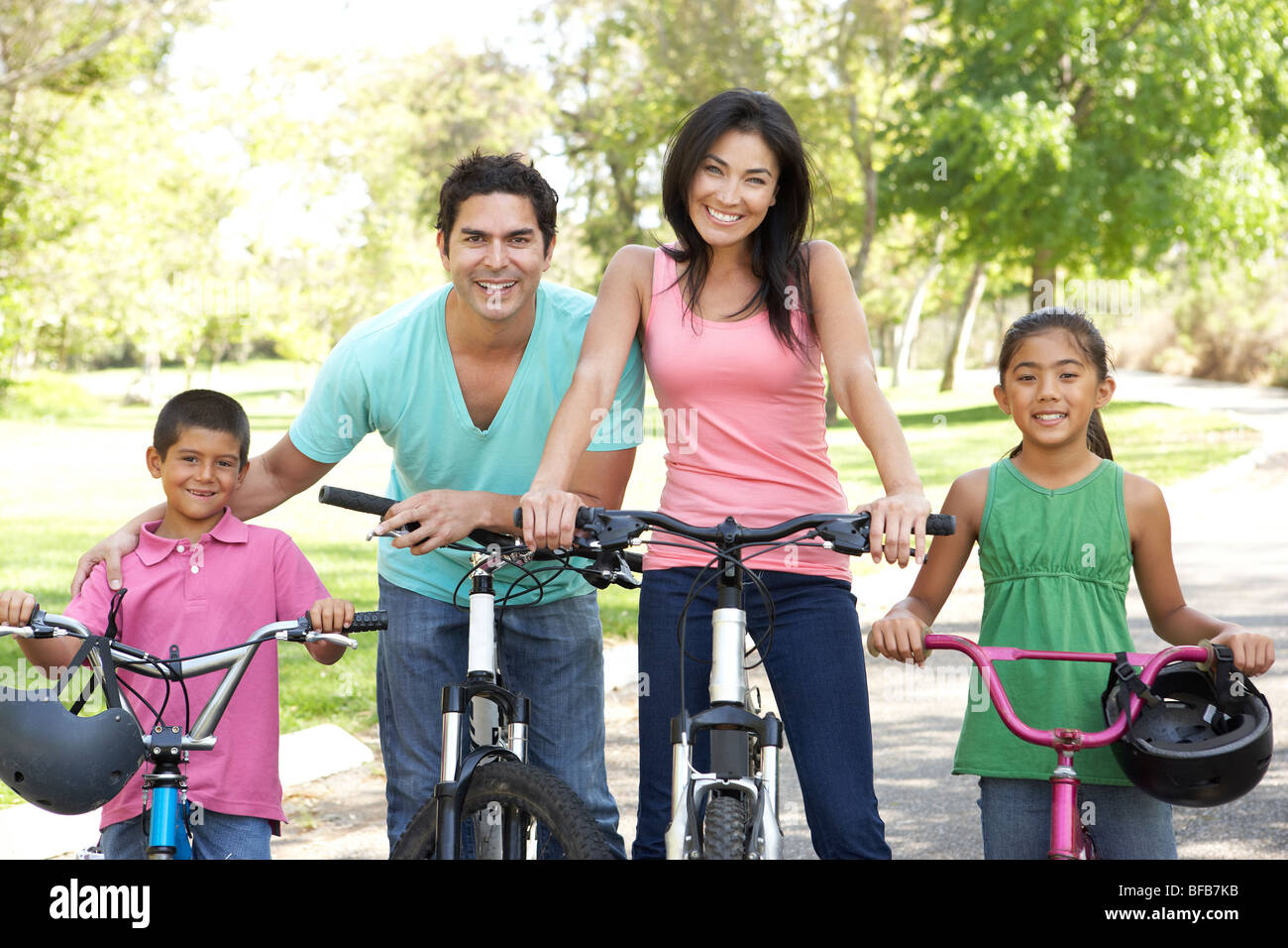 Young Family Riding Bikes In Park Stock Photo - Alamy