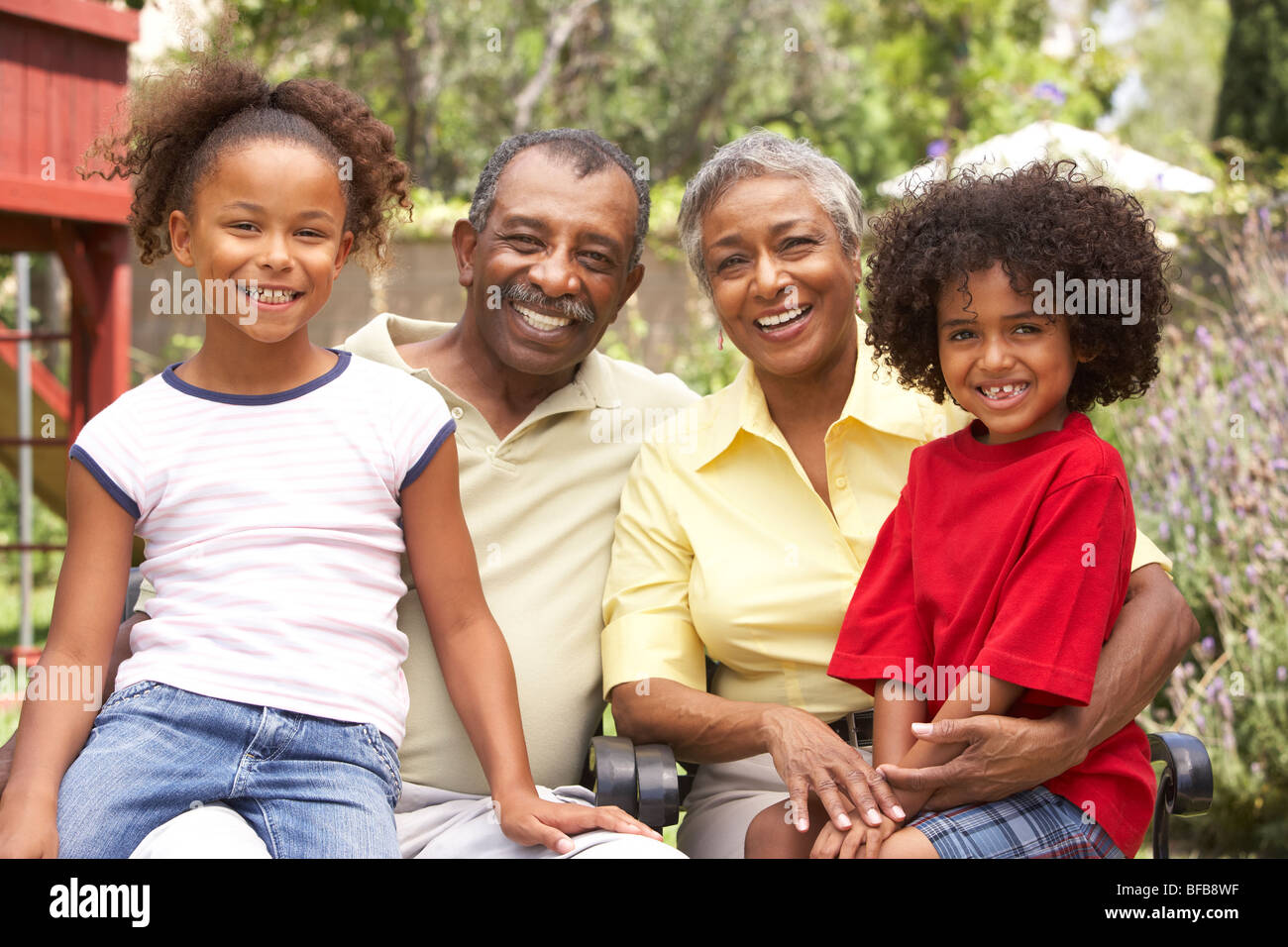 Grandparents Relaxing In Garden With Grandchildren Stock Photo - Alamy