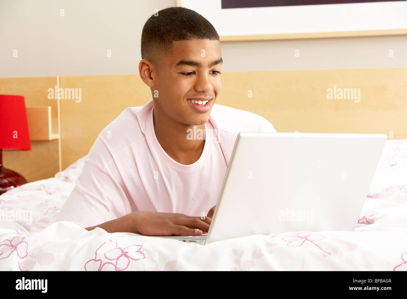 Teenage Boy Using Laptop In Bedroom Stock Photo - Alamy