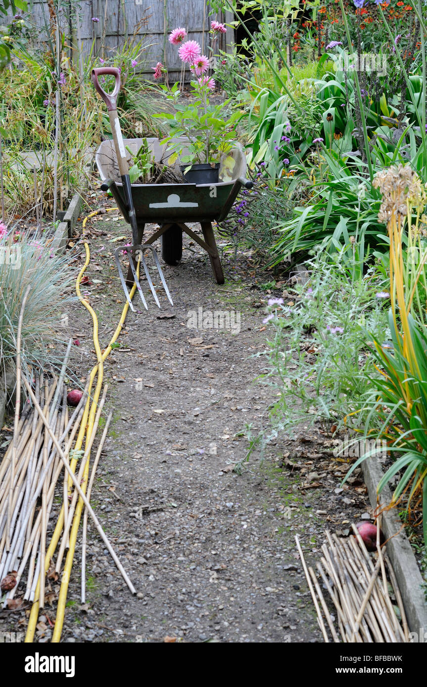 General view of urban garden with wheelbarrow and garden items, Norfolk ...