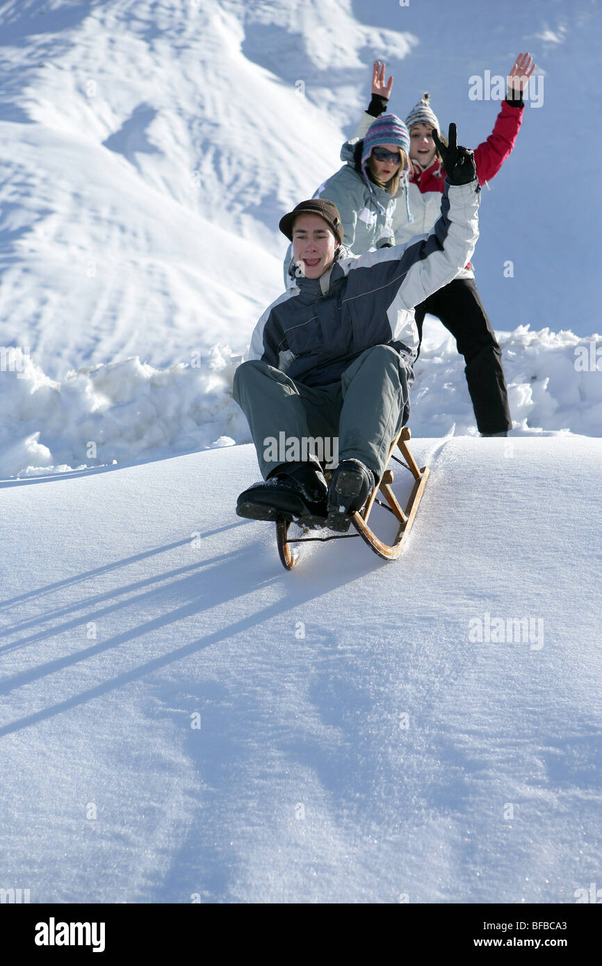 Friends playing with sledge Stock Photo - Alamy