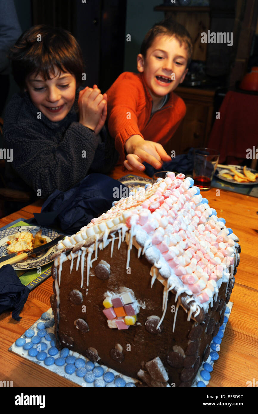 Children enjoy a gingerbread house at Christmas Stock Photo - Alamy