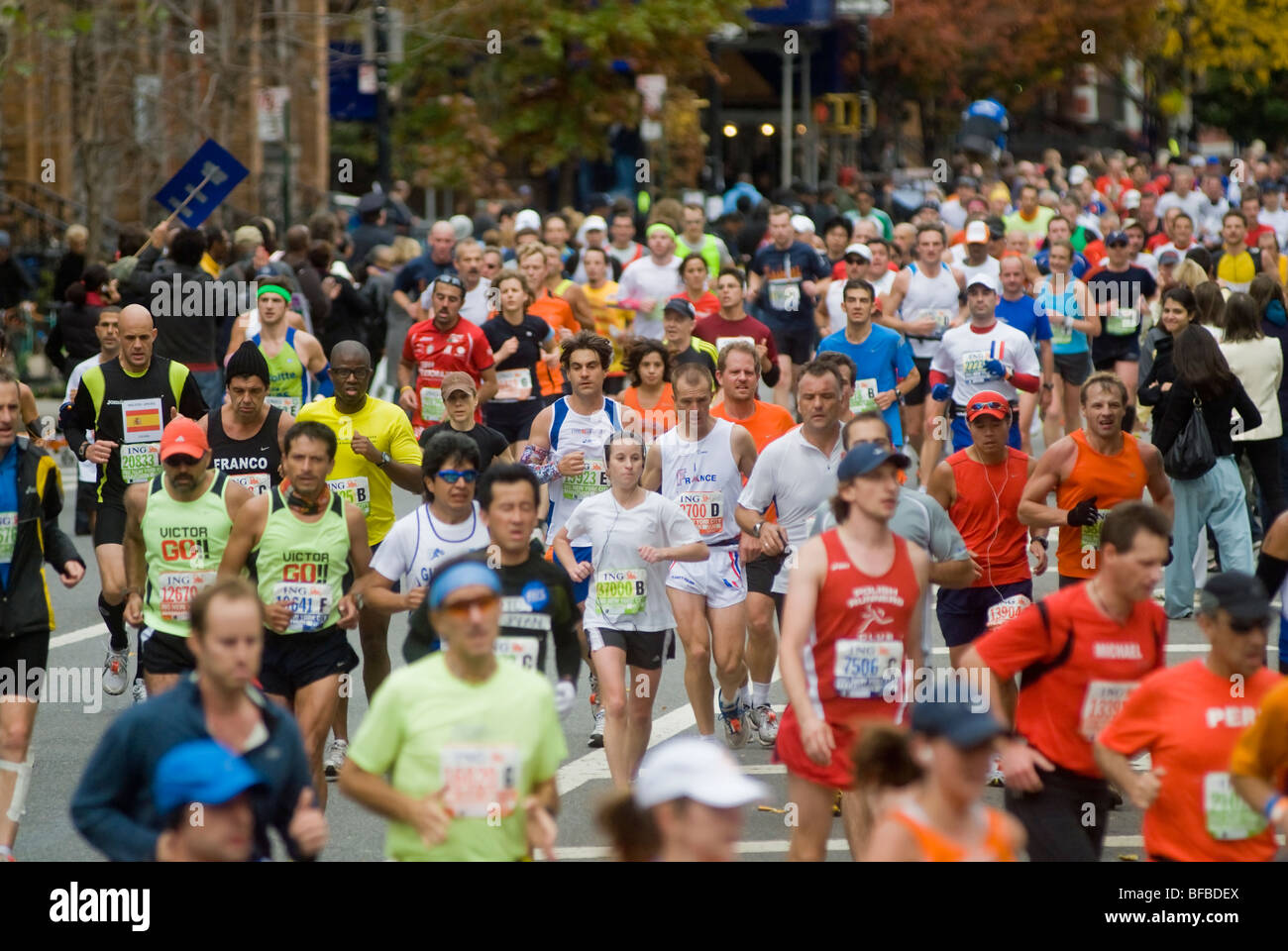 Runners pass through Harlem at the 22 mile marker near Mount Morris ...