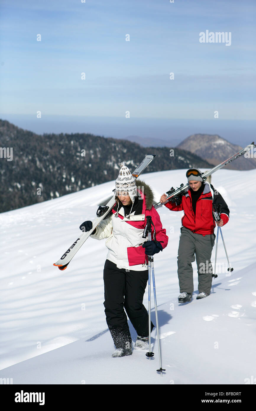 Young people walking across a mountain with skis Stock Photo - Alamy