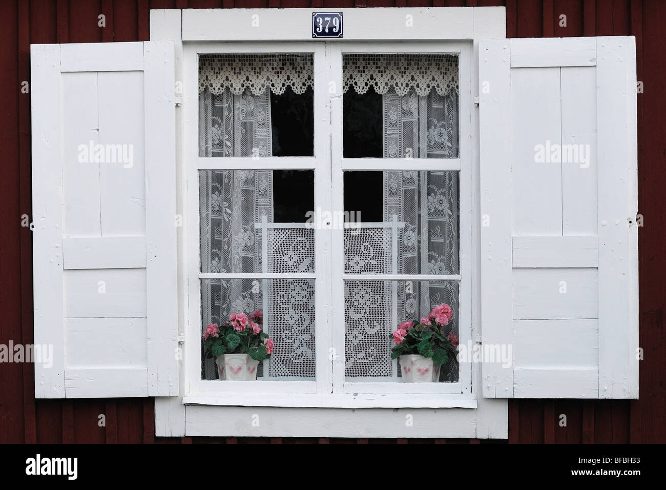 A typical old-fashioned Swedish window decorated with white curtains ...