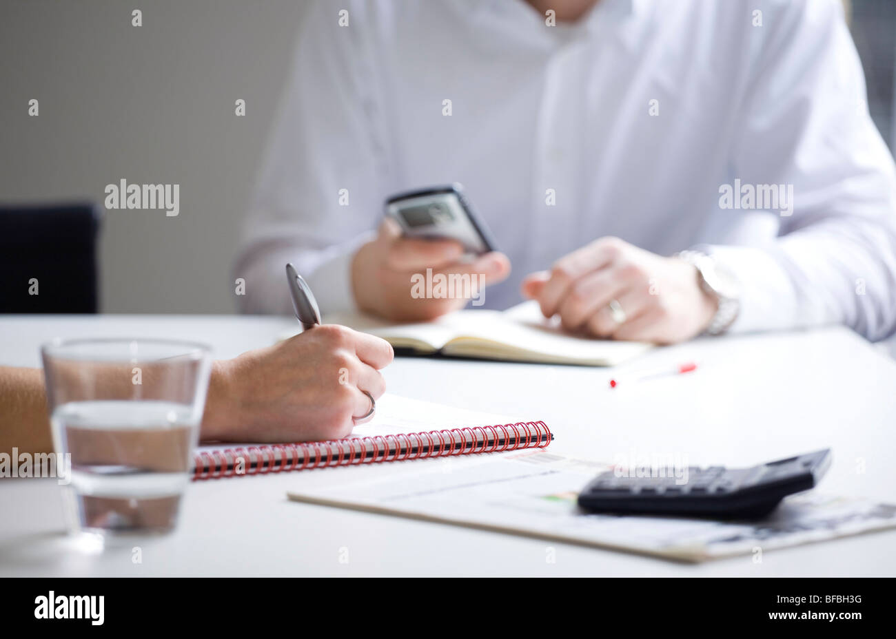 Business meeting taking notes and receiving email Stock Photo - Alamy