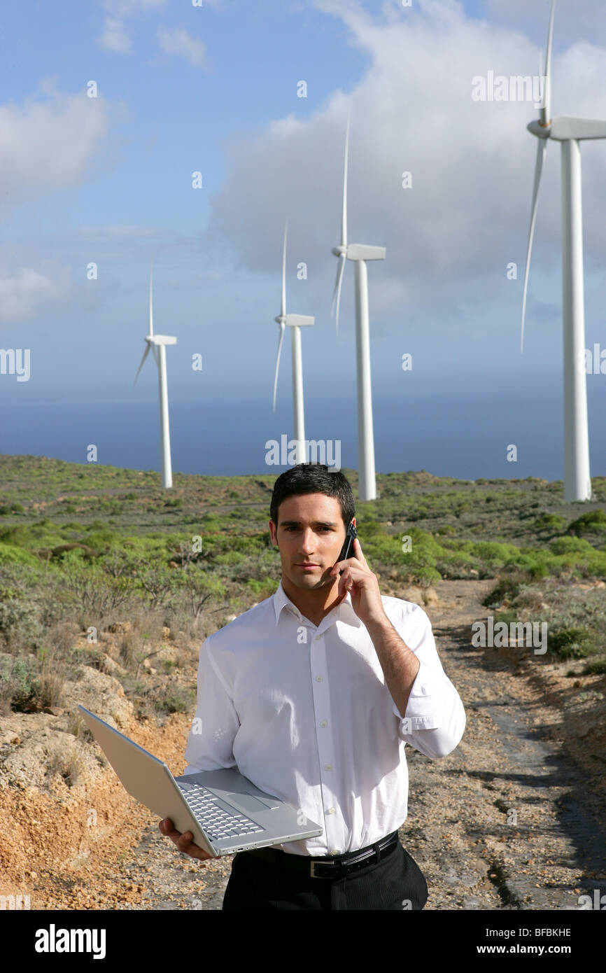 Man with laptop stood by wind farm Stock Photo - Alamy