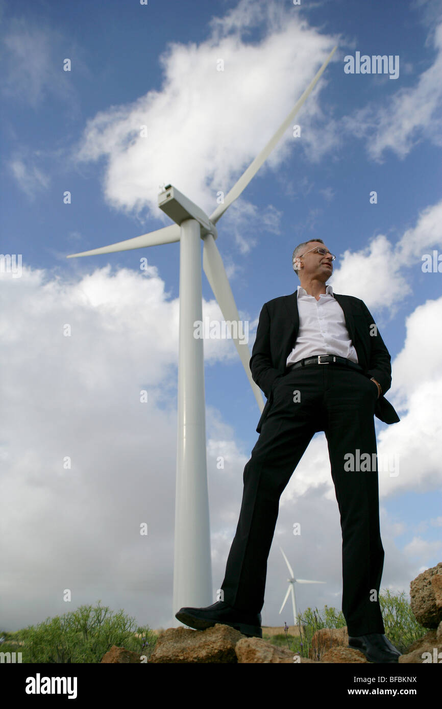 Man standing next to a wind turbine Stock Photo - Alamy