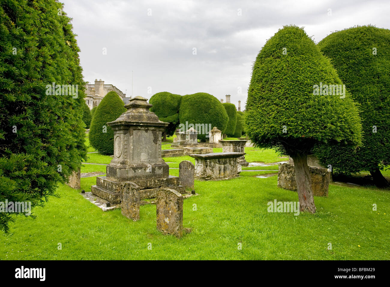 Tombs and yew trees in churchyard of St Mary's Church Painswick Stock ...
