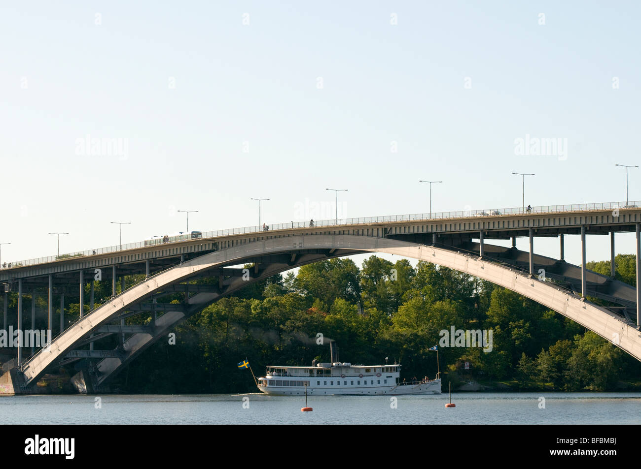 Small passenger ferry passing under a bridge Stock Photo - Alamy