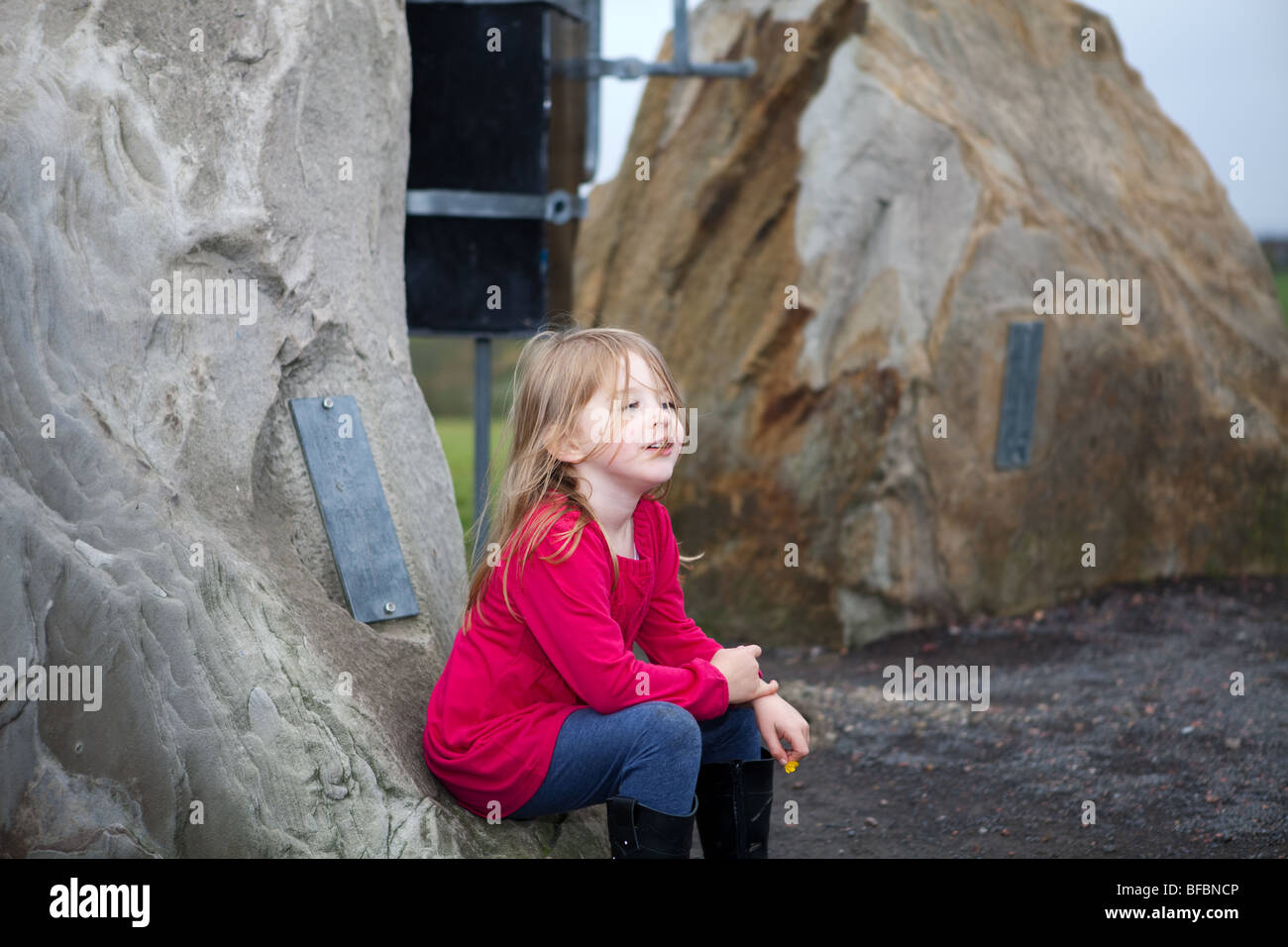 little girl sits on stone Stock Photo - Alamy