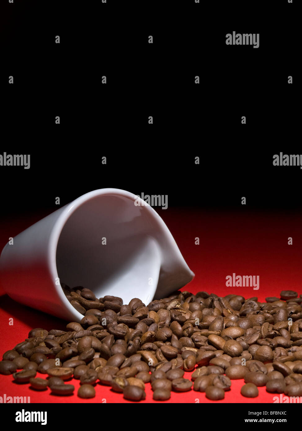 A fallen cup with coffee beans spread out Stock Photo - Alamy