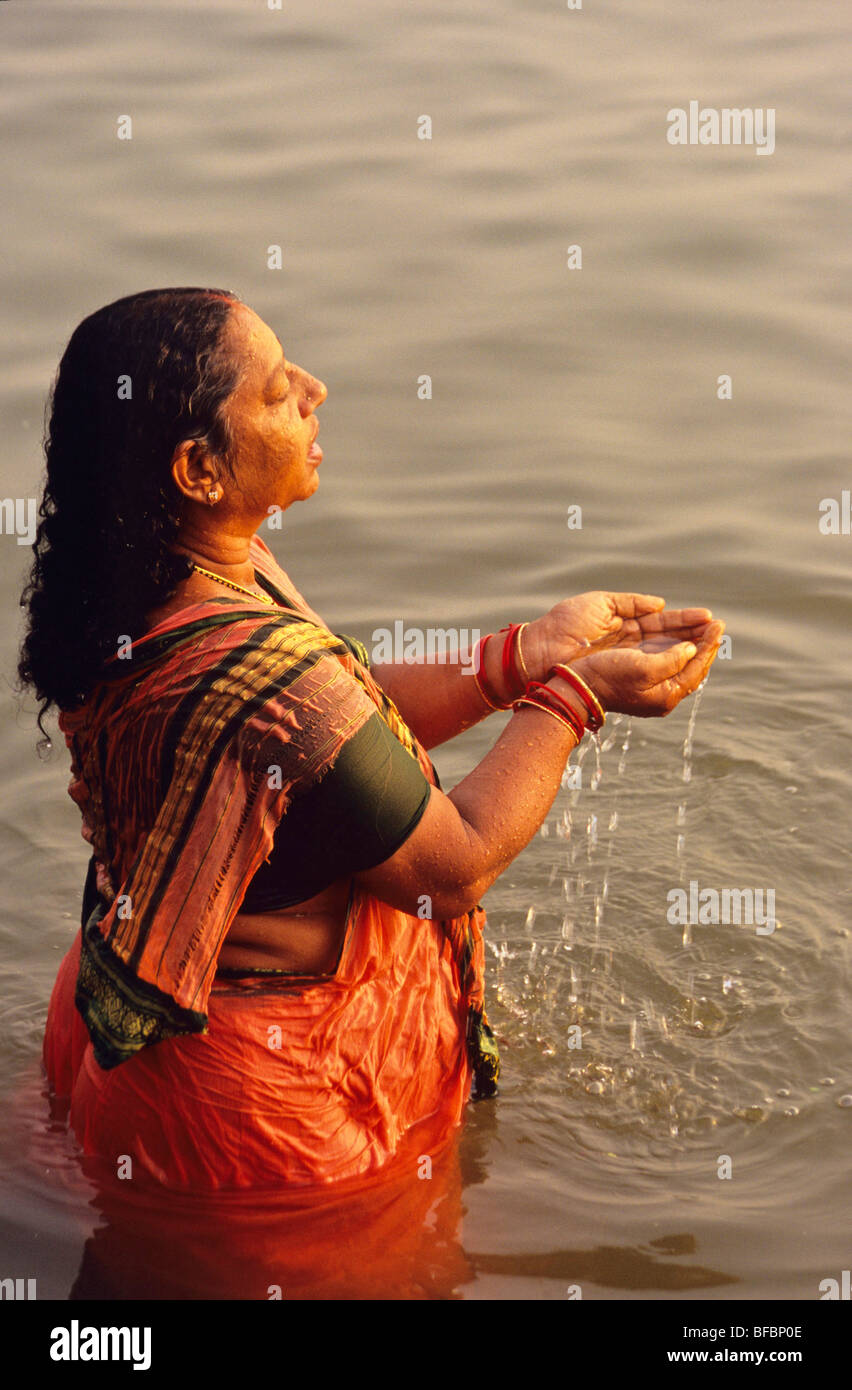 This devotee takes the holy water of the River Ganges in cupped hands ...