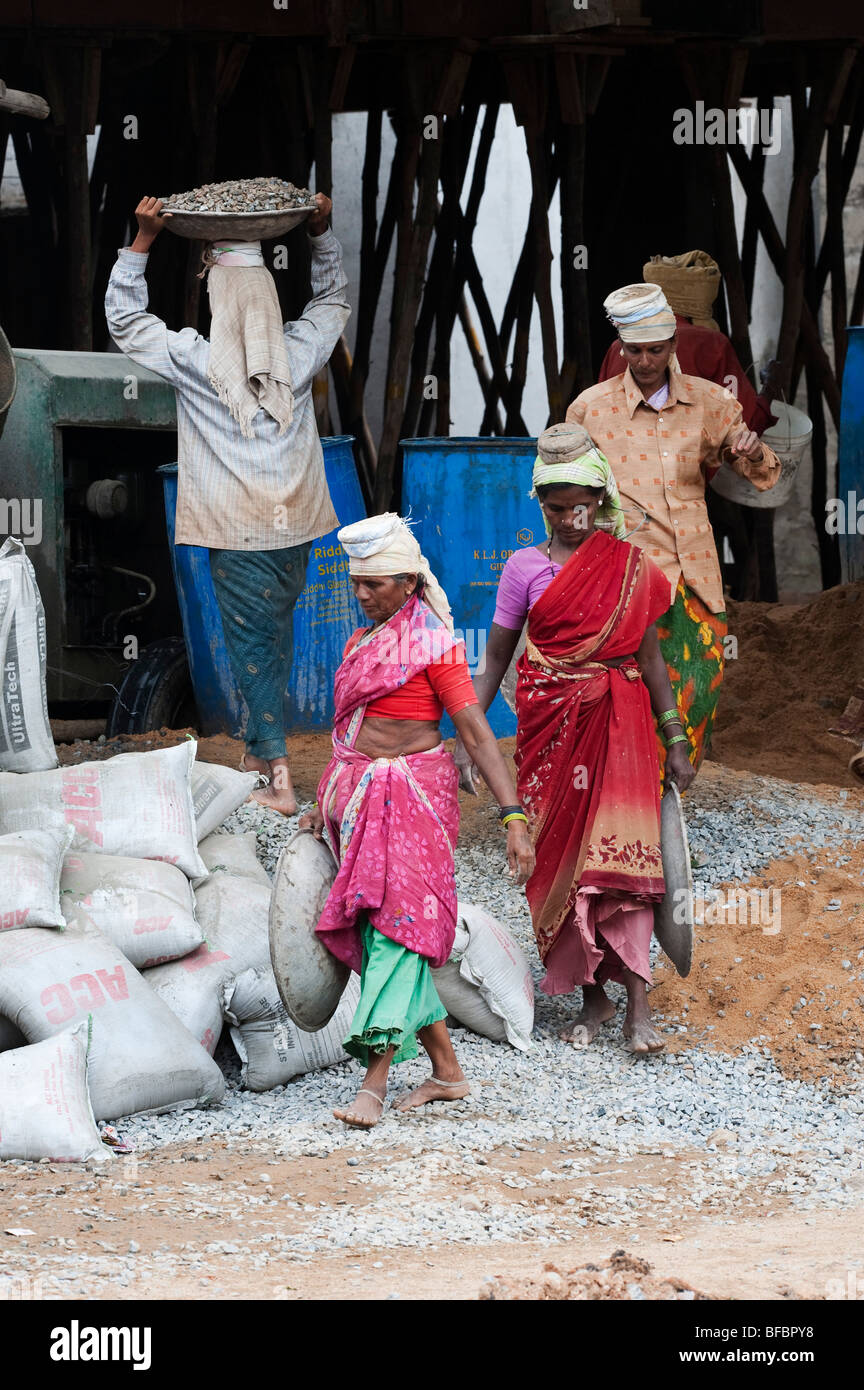 Indian women working on a building site, carrying sand and stone on ...