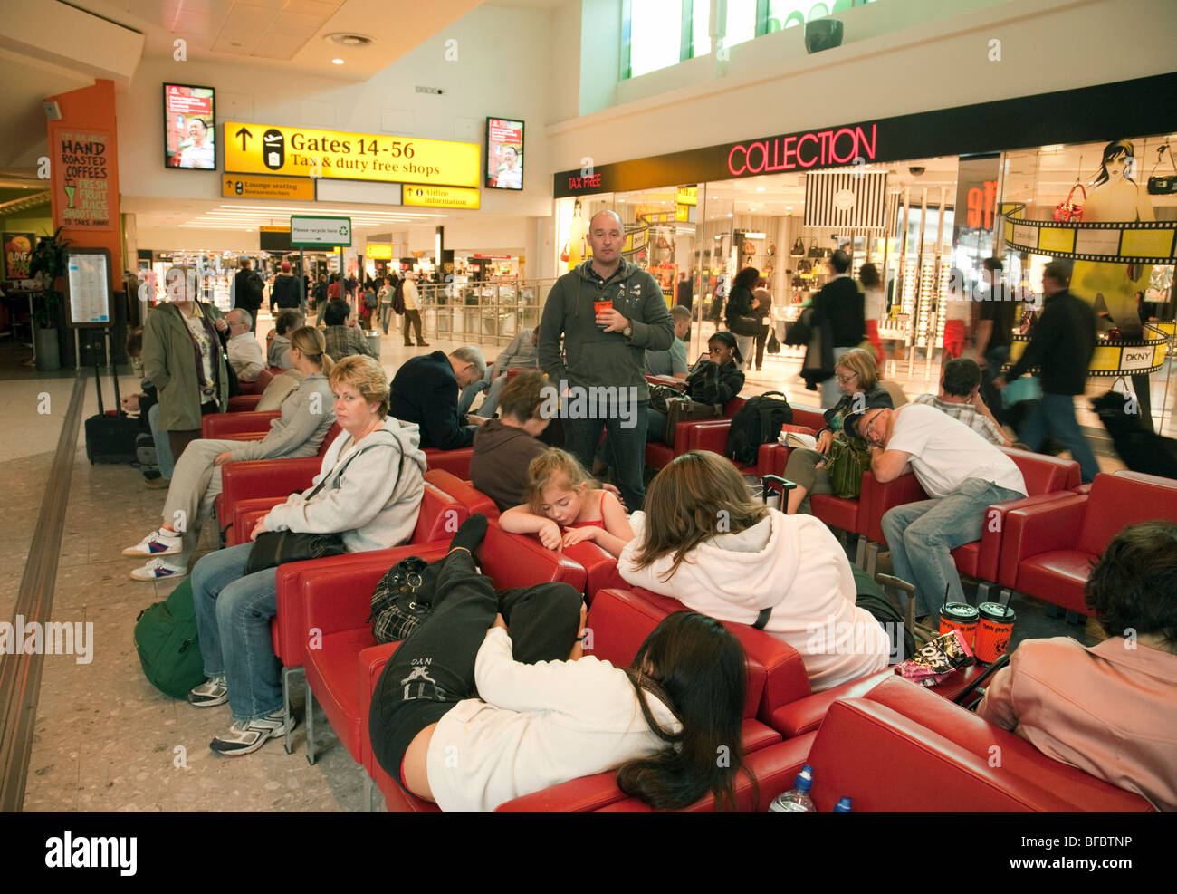 Tired airline travellers resting in the departure lounge, Terminal One ...